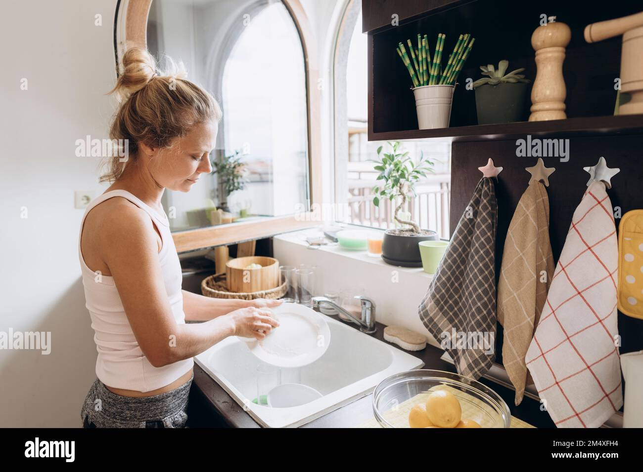 Woman washing dishes with salt in the kitchen Stock Photo - Alamy