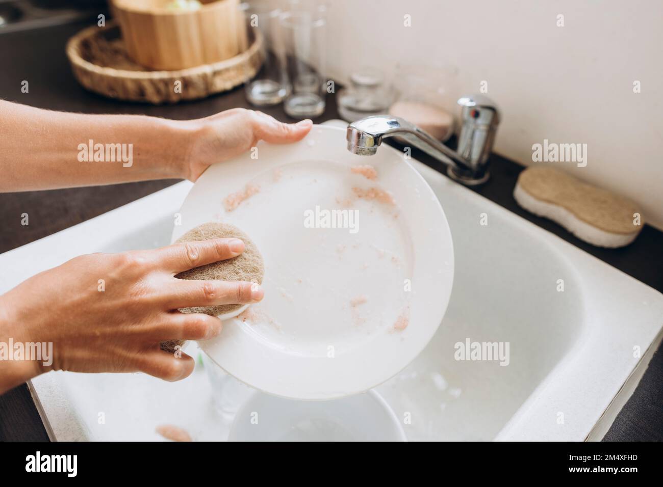 Woman washing dishes with salt in the kitchen Stock Photo - Alamy