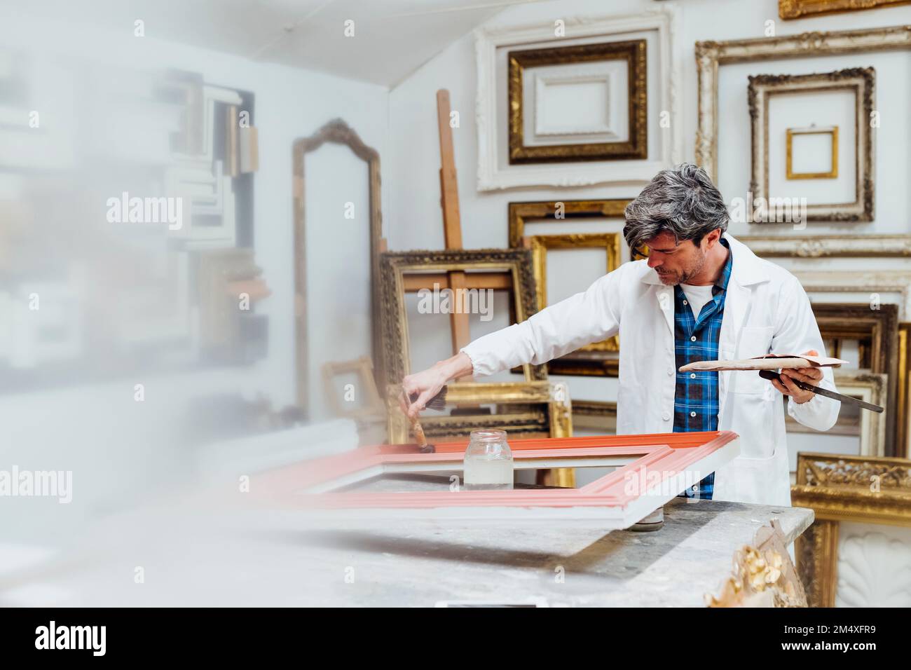 Craftsman polishing frame in workshop Stock Photo - Alamy