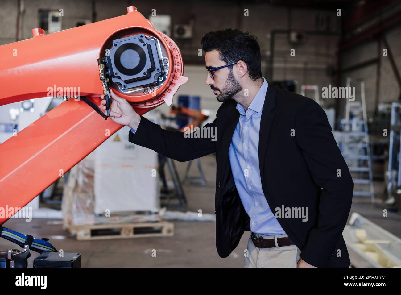 Engineer examining robotic arm in industry Stock Photo - Alamy