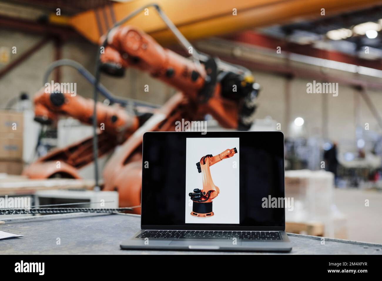 Laptop with robotic arm photograph at desk in industry Stock Photo - Alamy