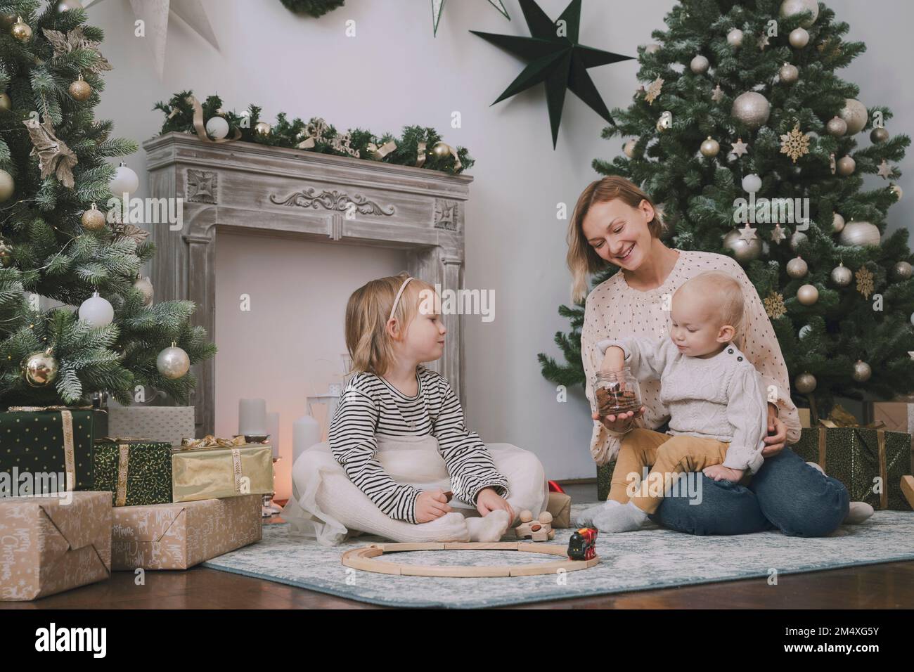 Mother giving candy to children at home Stock Photo - Alamy