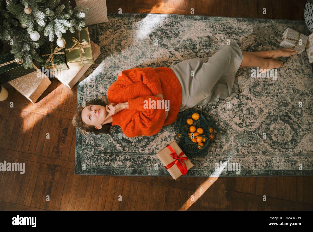 Contemplative woman lying on carpet at home Stock Photo - Alamy