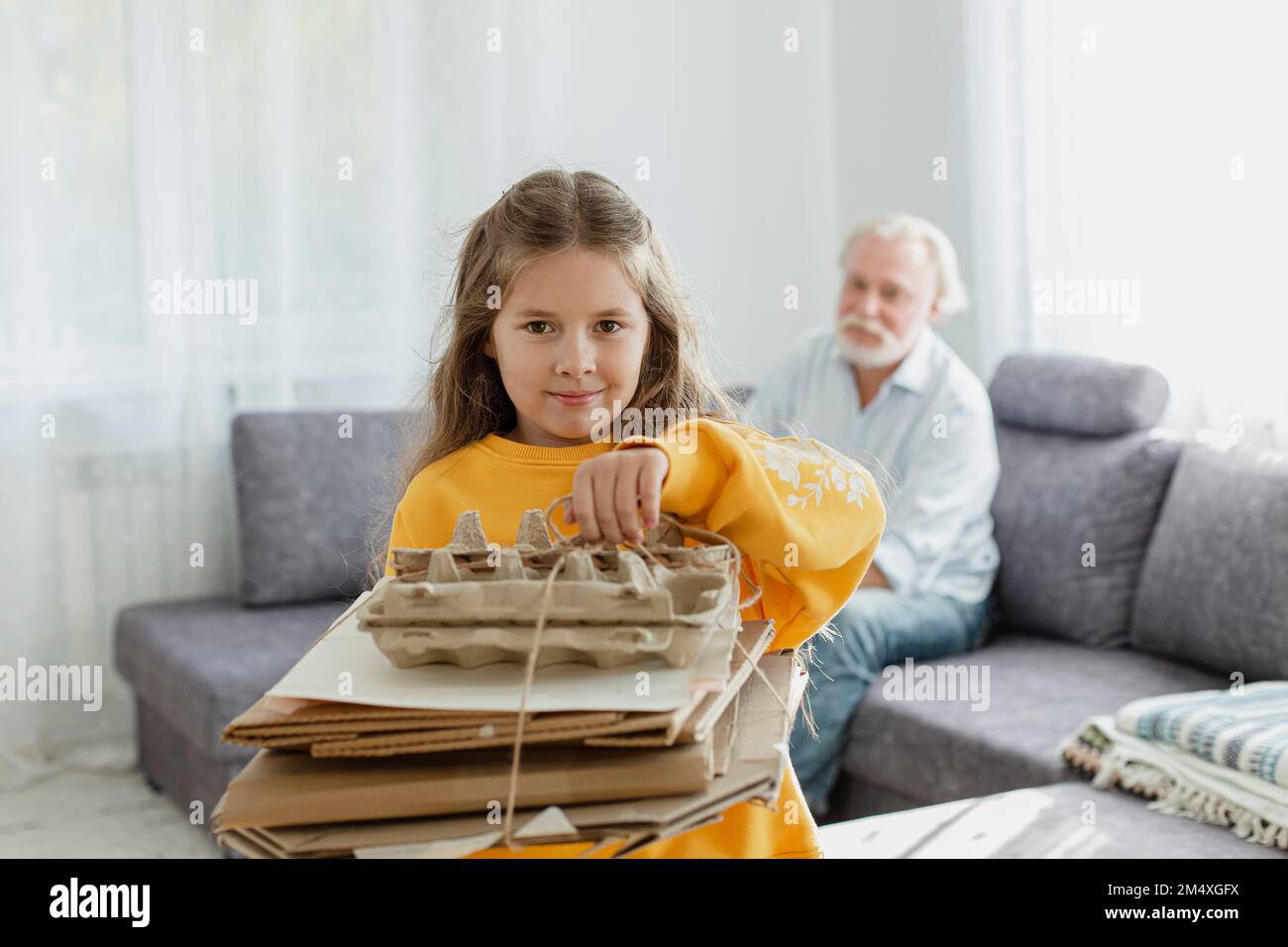 Girl carrying bunch of waste paper at home Stock Photo - Alamy