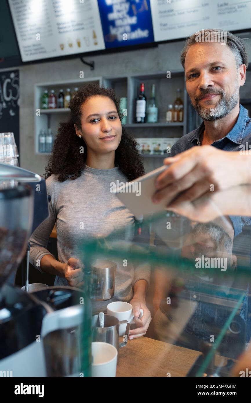 Confident cafe owner and barista at counter in coffee shop Stock Photo ...