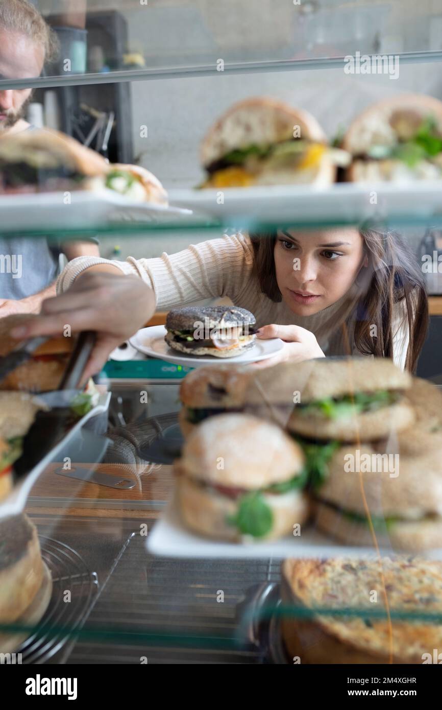 Barista taking burgers from display counter in cafe Stock Photo - Alamy