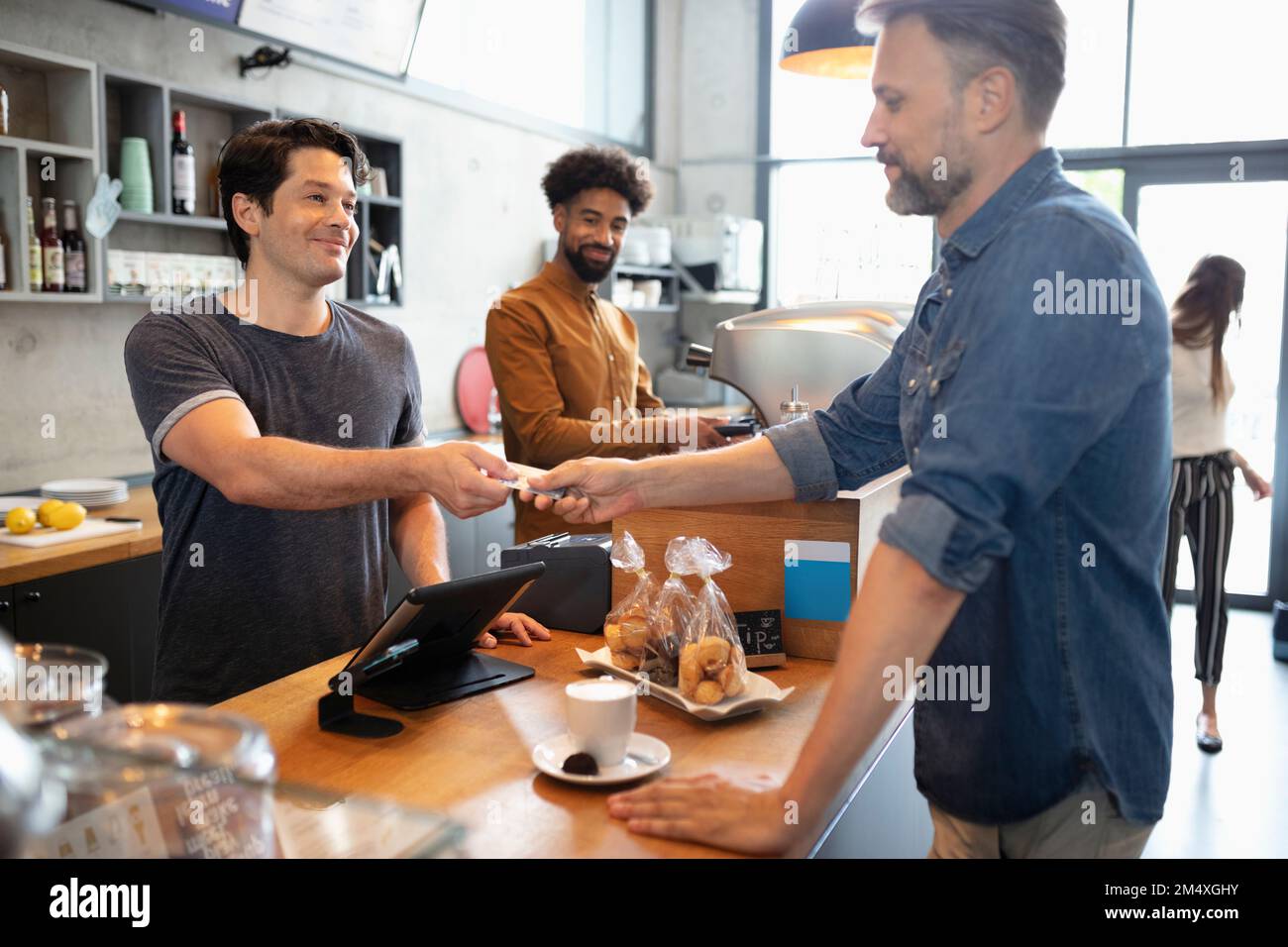 Customer paying through credit card at counter in cafe Stock Photo - Alamy