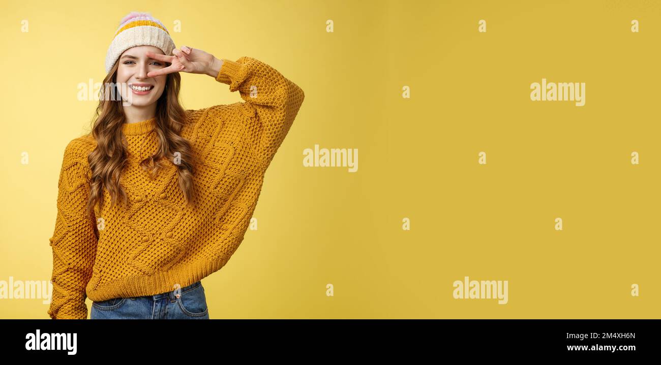 Positive peaceful kind charming young woman show peace victory gesture ...