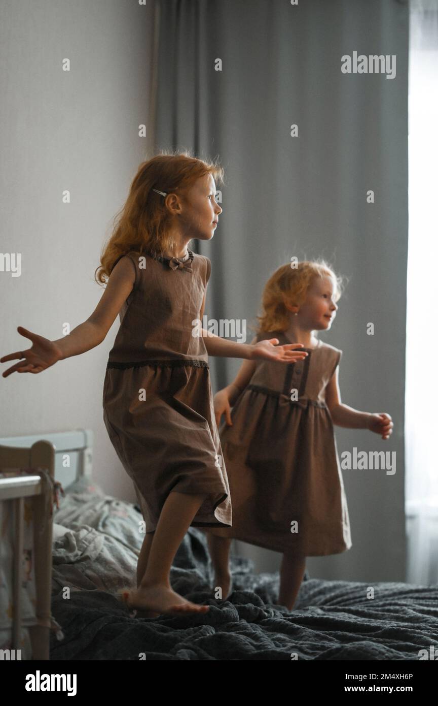 Happy siblings jumping and dancing on bed at home Stock Photo - Alamy