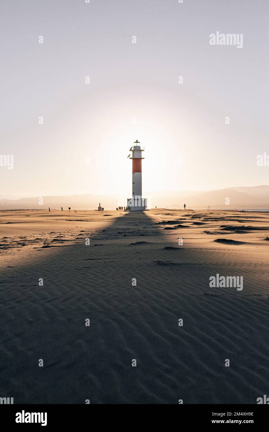 Shadow of lighthouse on sand at beach Stock Photo - Alamy