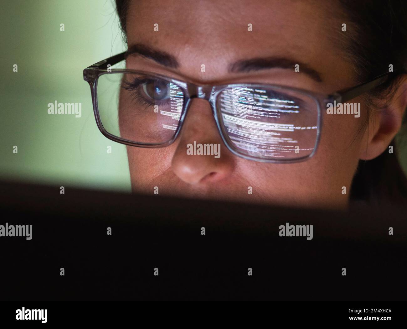 Computer programmer wearing eyeglasses looking at codes Stock Photo - Alamy