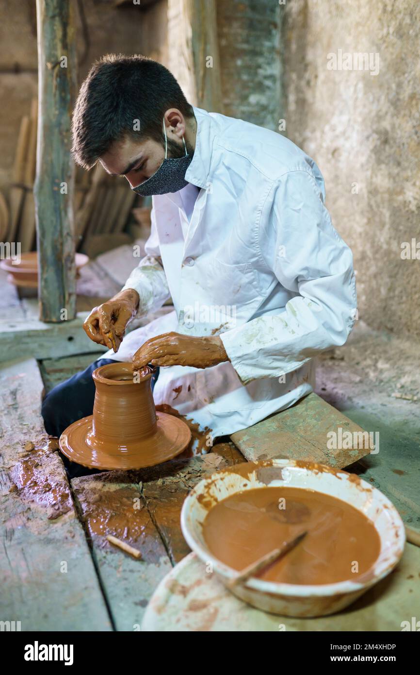 Craftsman preparing ceramic on pottery wheel in factory Stock Photo - Alamy