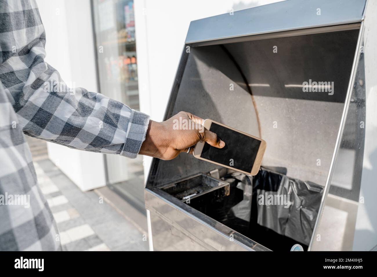 Man trashing smart phone in dustbin Stock Photo - Alamy