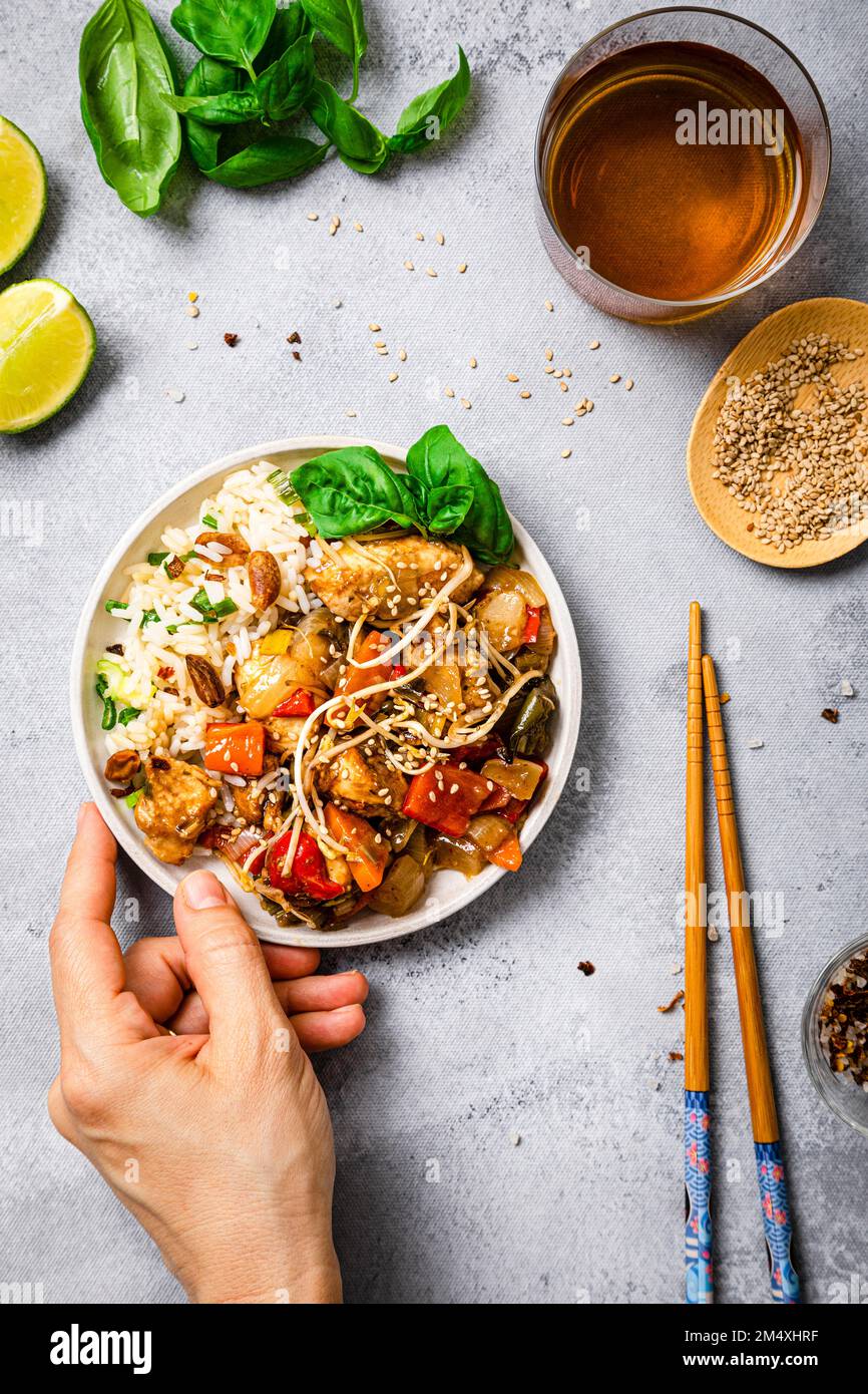 Hand of woman picking up plate of chop suey Stock Photo - Alamy