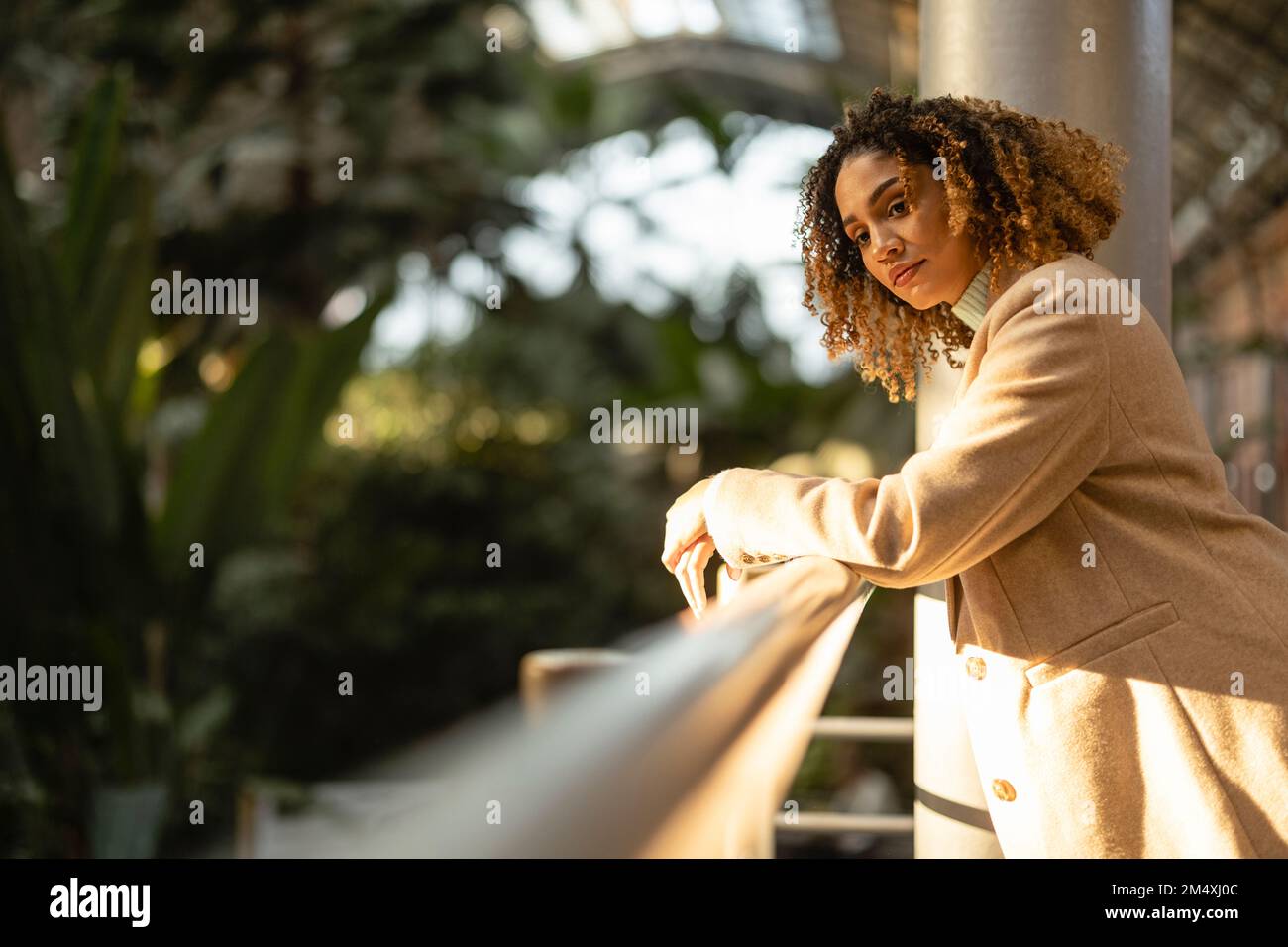 Thoughtful woman leaning on railing Stock Photo - Alamy