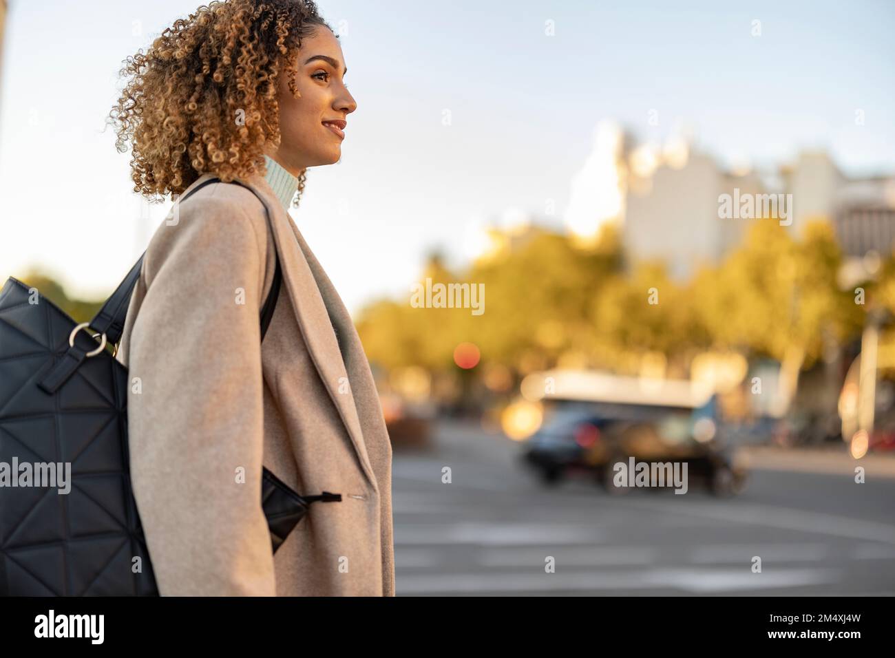 Smiling beautiful young woman with curly hair Stock Photo - Alamy