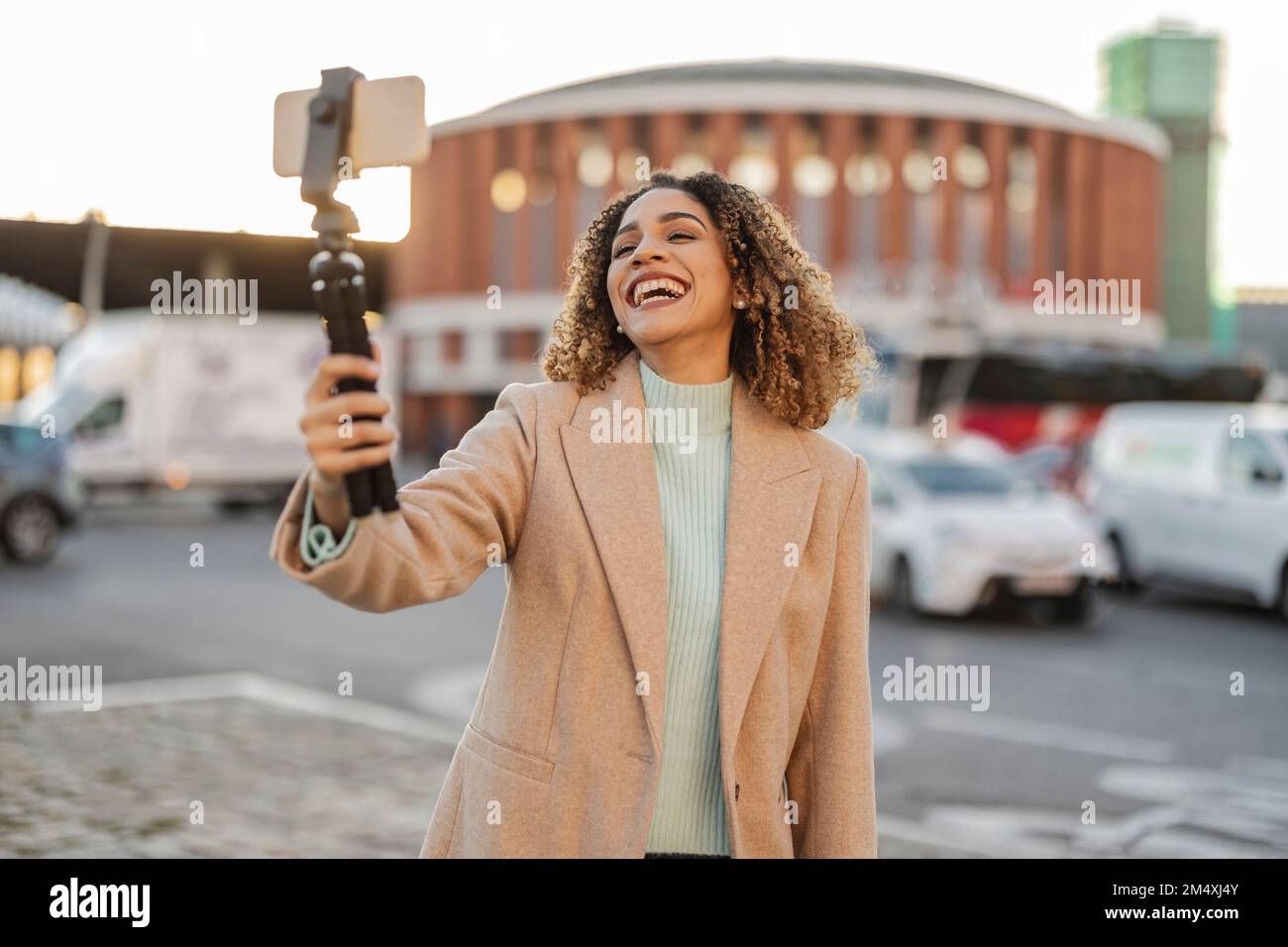 Happy woman filming through mobile phone on tripod Stock Photo - Alamy