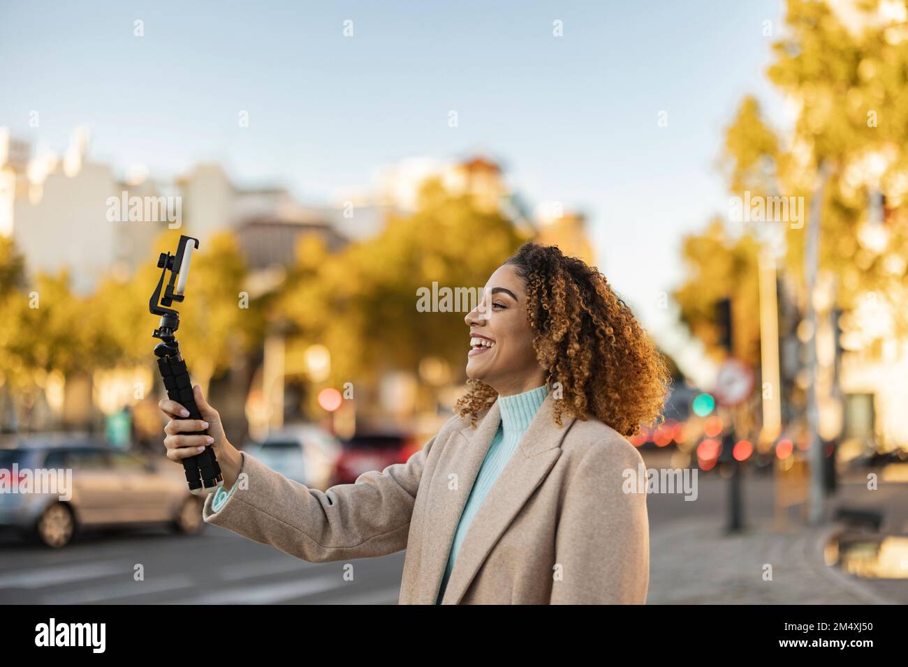 Happy young woman filming through smart phone on tripod Stock Photo - Alamy