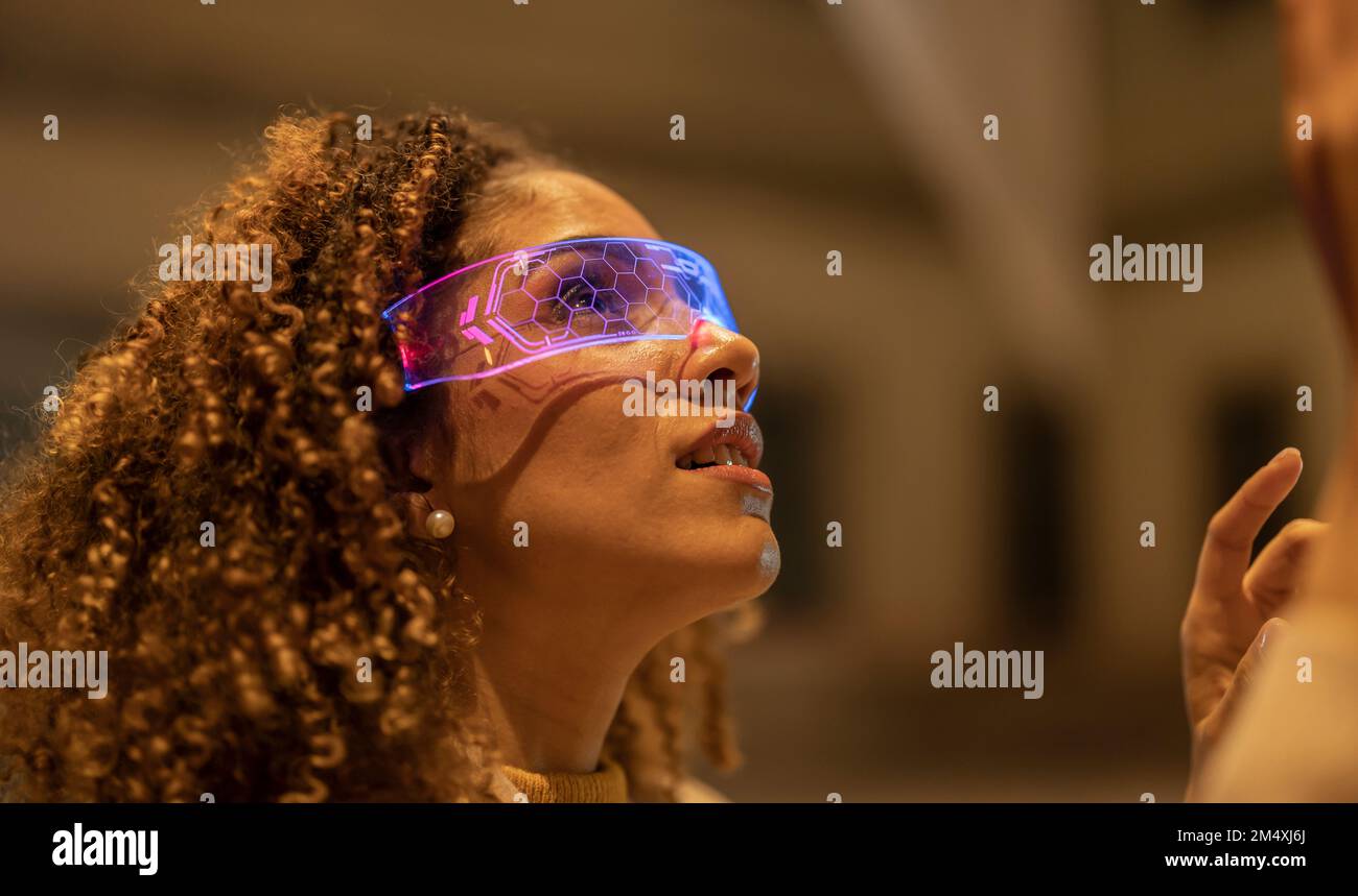 Young woman wearing smart glasses at night Stock Photo - Alamy