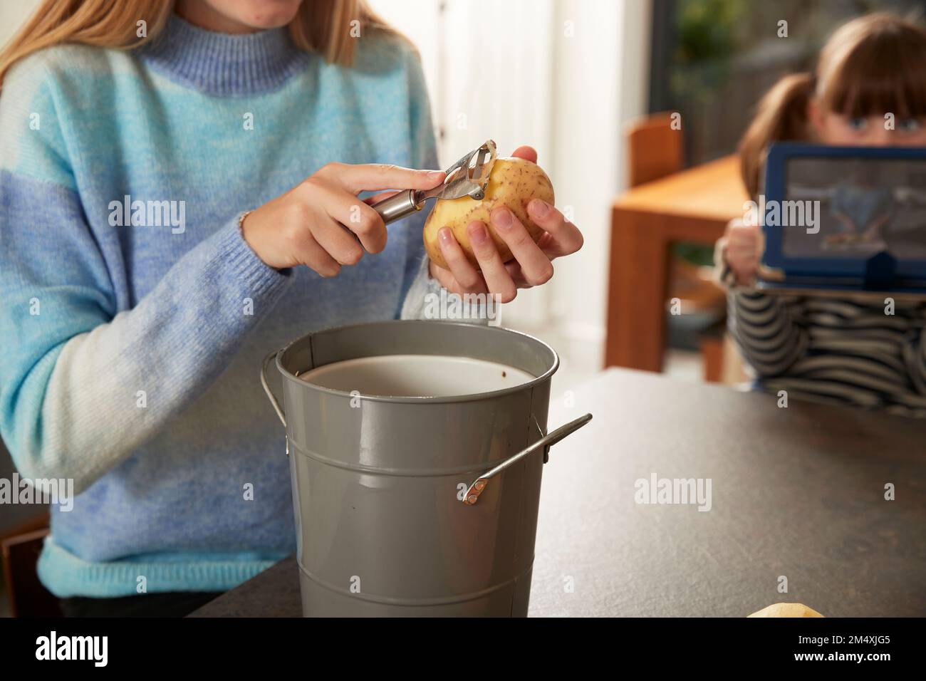 Girl peeling potato in kitchen at home Stock Photo - Alamy