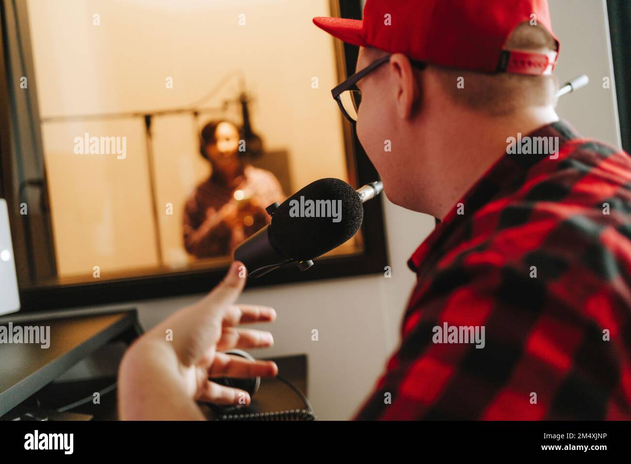 Musician talking with singer through microphone at studio Stock Photo ...