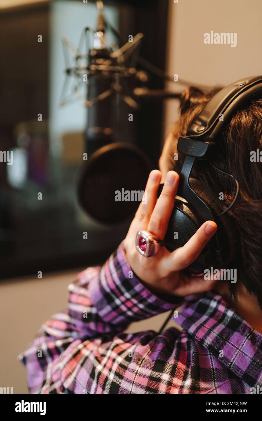 Hand of singer on headphones in studio Stock Photo - Alamy