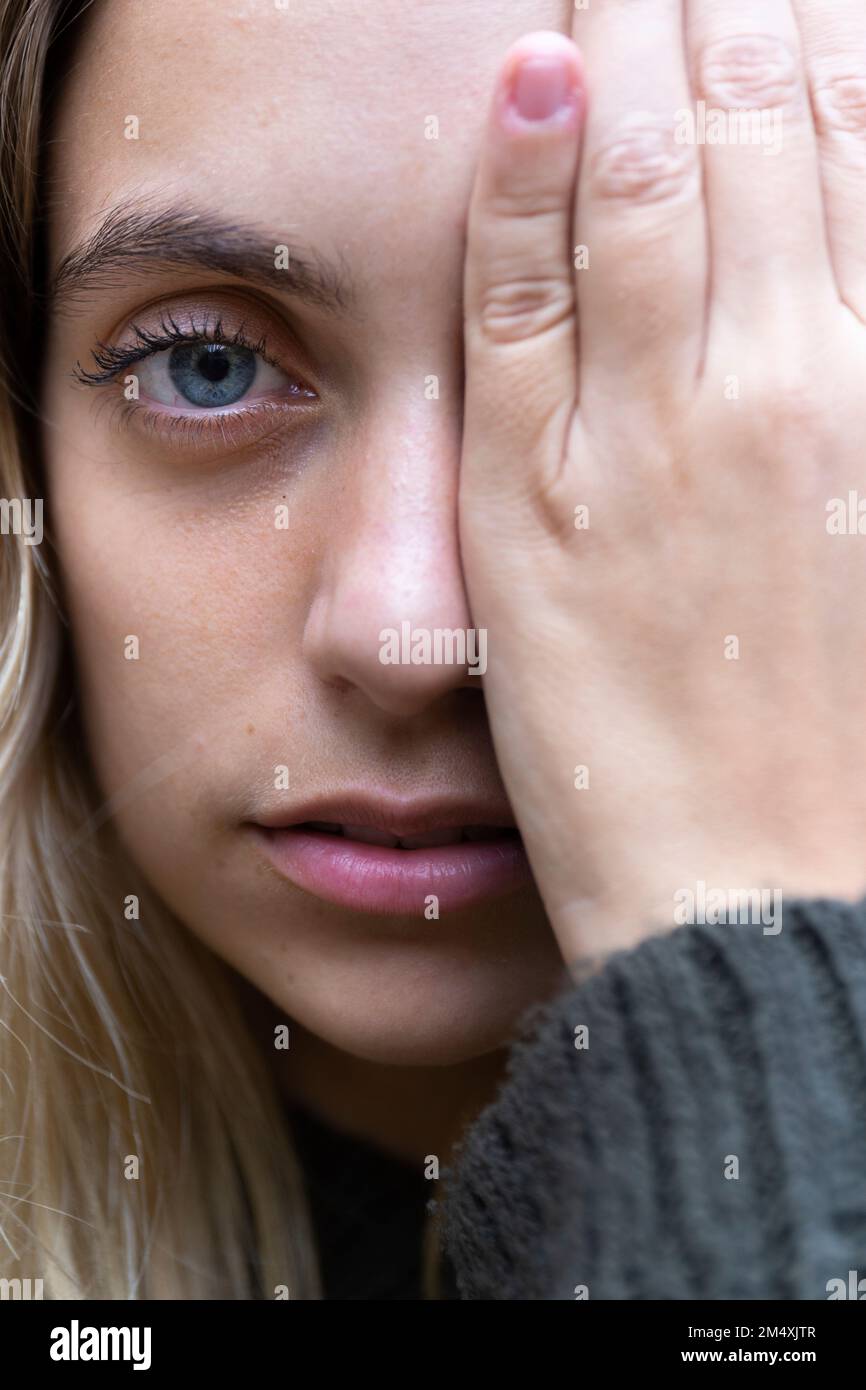 Young woman covering face with hand Stock Photo - Alamy