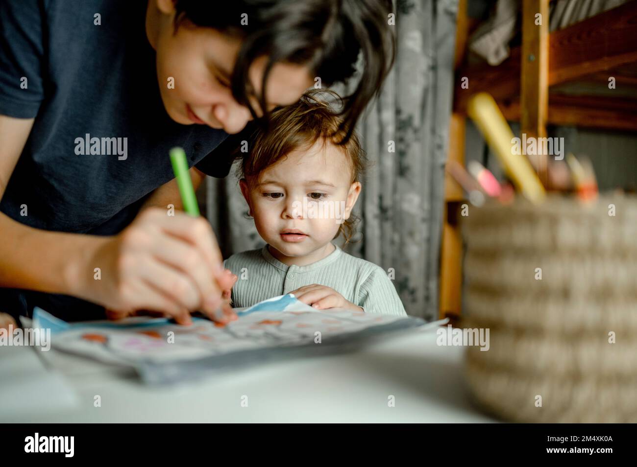 Boy teaching drawing to baby brother at home Stock Photo - Alamy