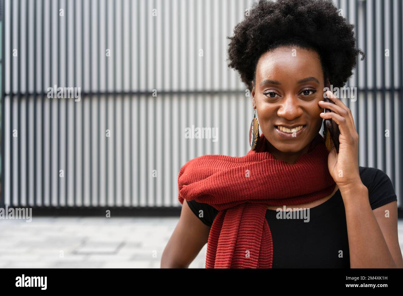 Happy woman talking on mobile phone on footpath Stock Photo - Alamy