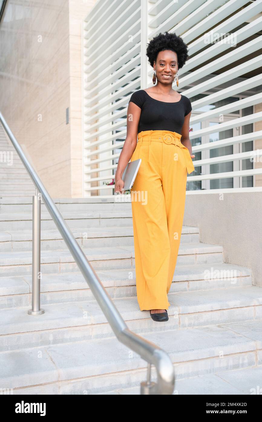 Happy woman moving down staircase Stock Photo - Alamy