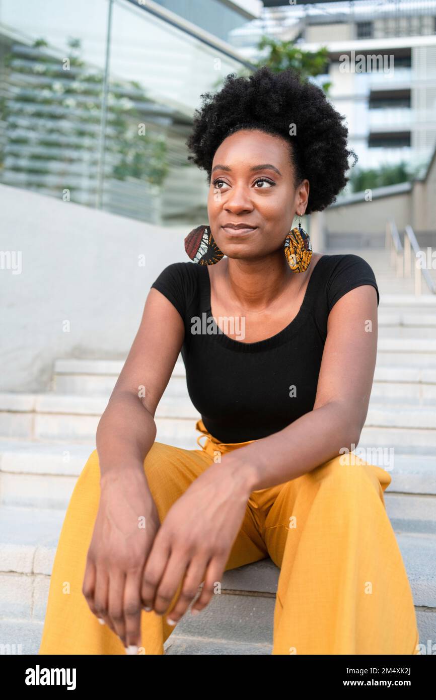 Contemplative woman sitting on staircase Stock Photo - Alamy
