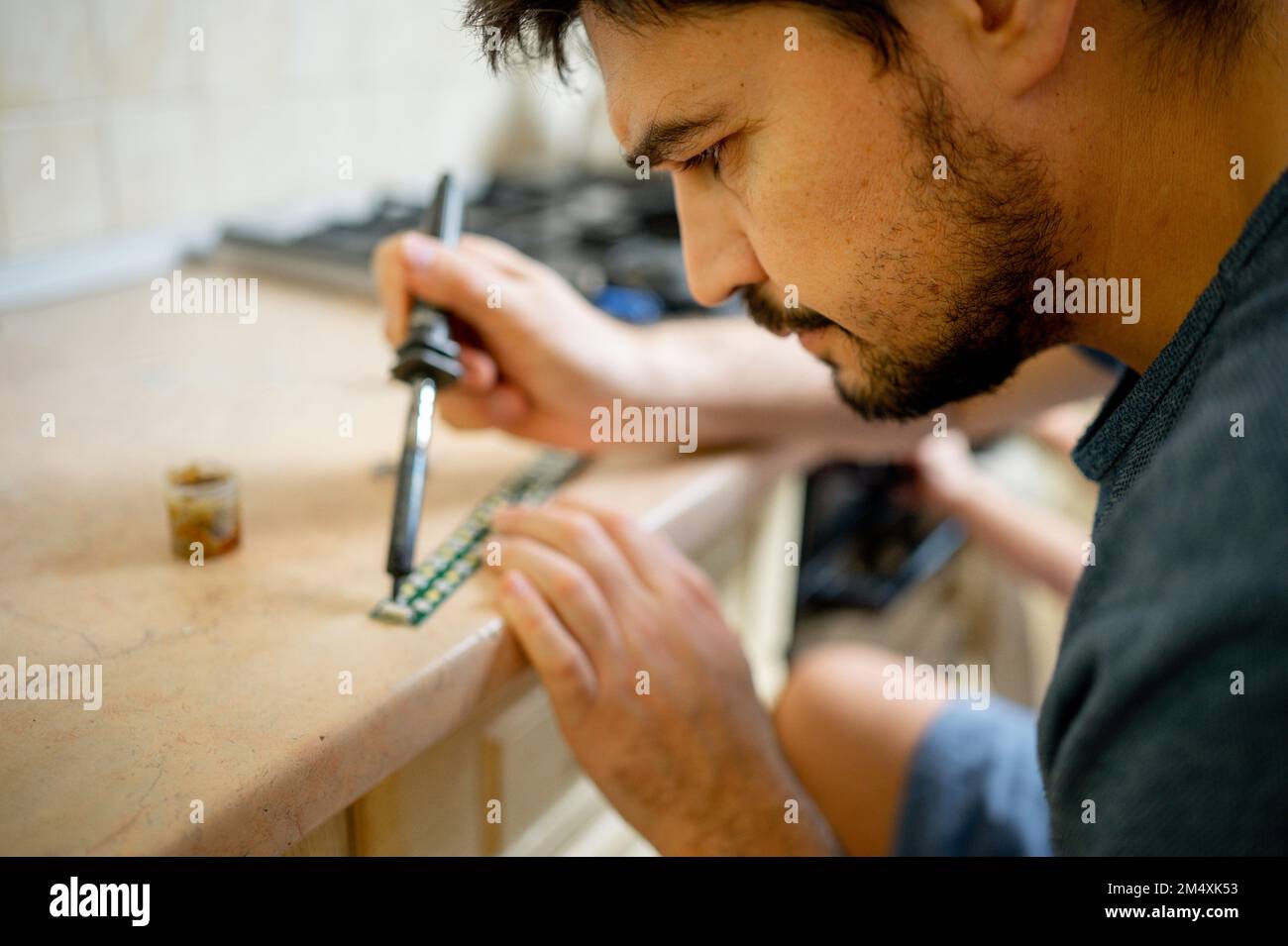 Technician soldering circuit board at workshop Stock Photo - Alamy