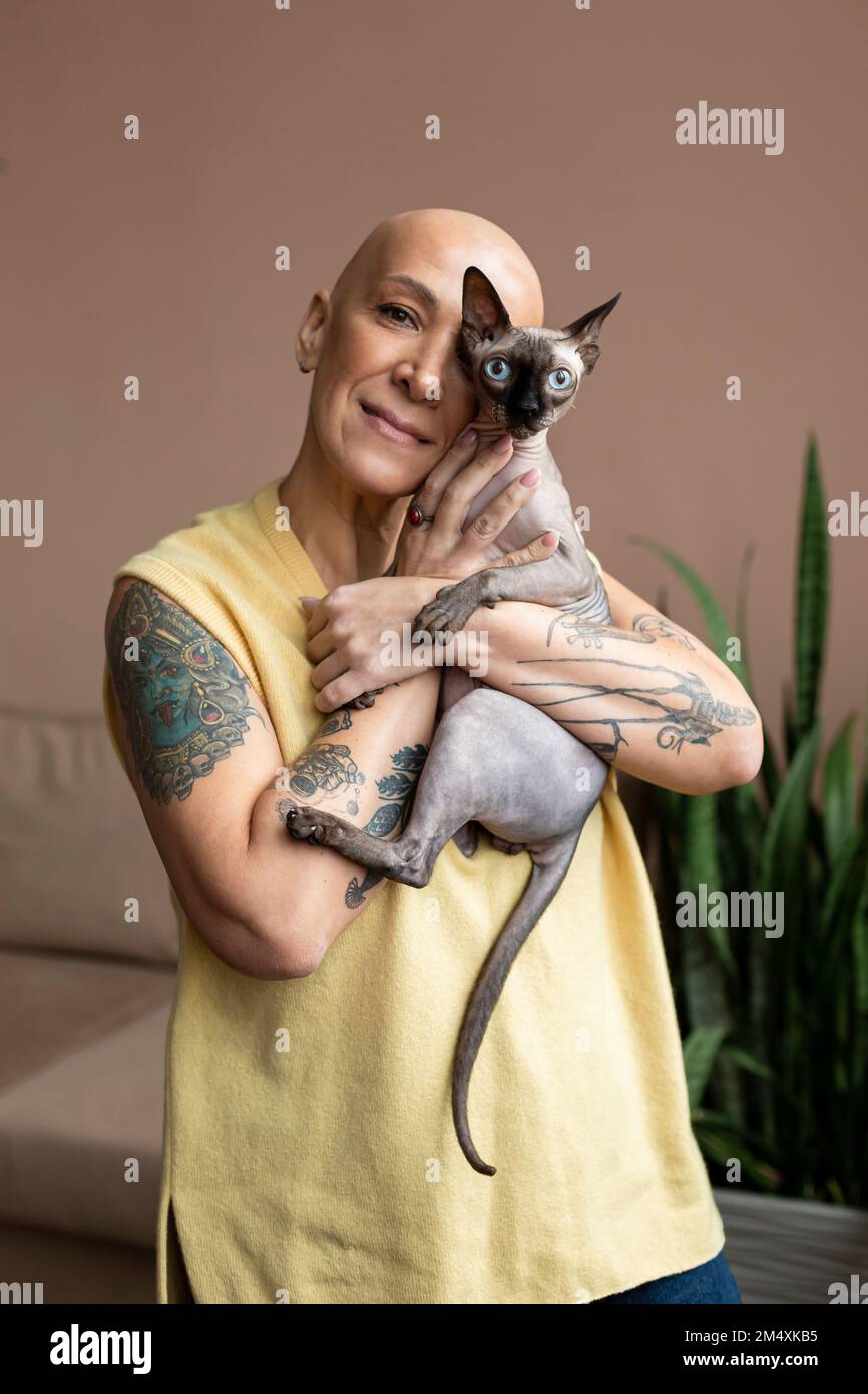 Hairless woman holding Sphynx cat in her arms Stock Photo - Alamy