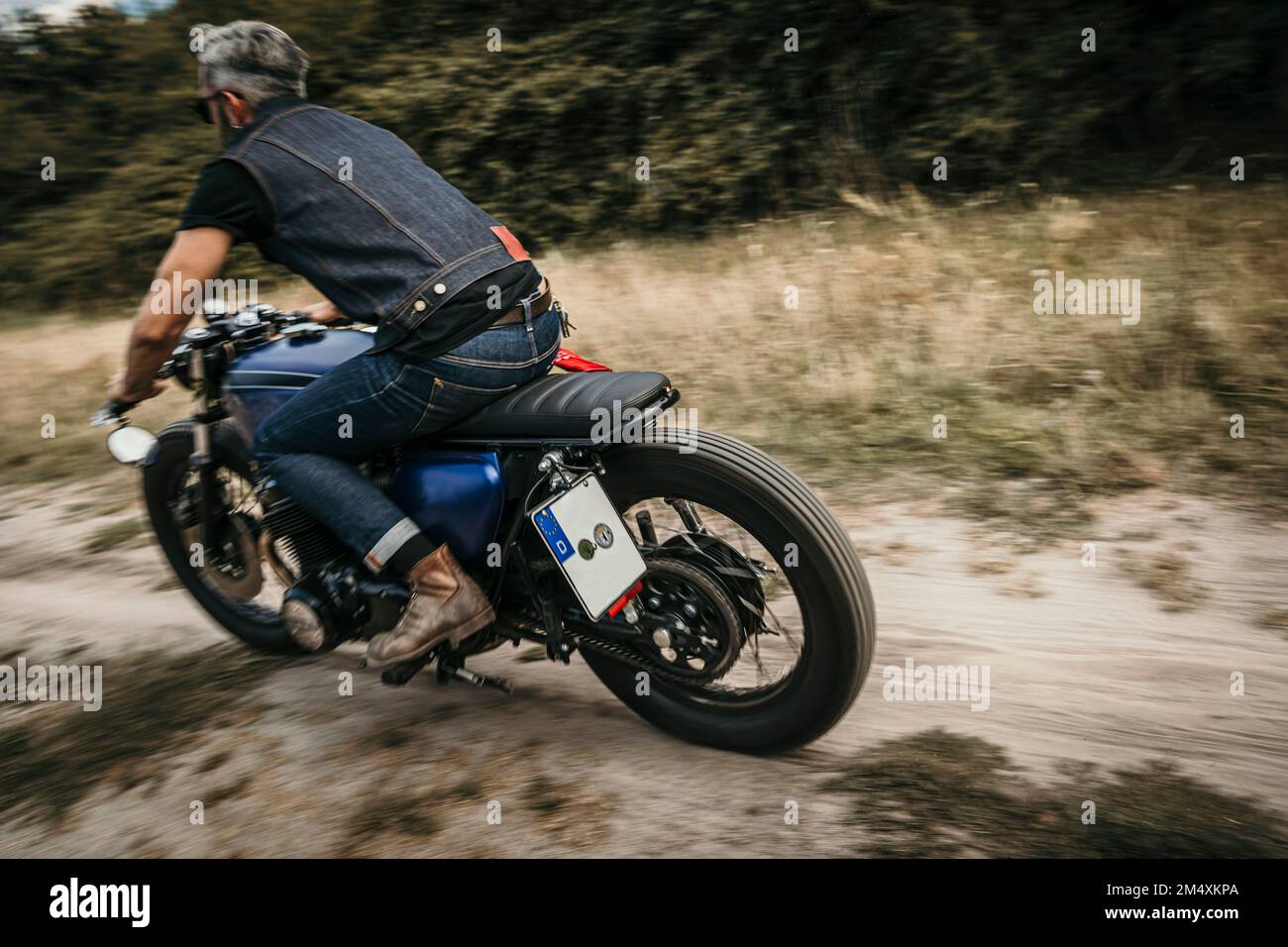 Mature biker riding motorcycle on dirt road Stock Photo - Alamy