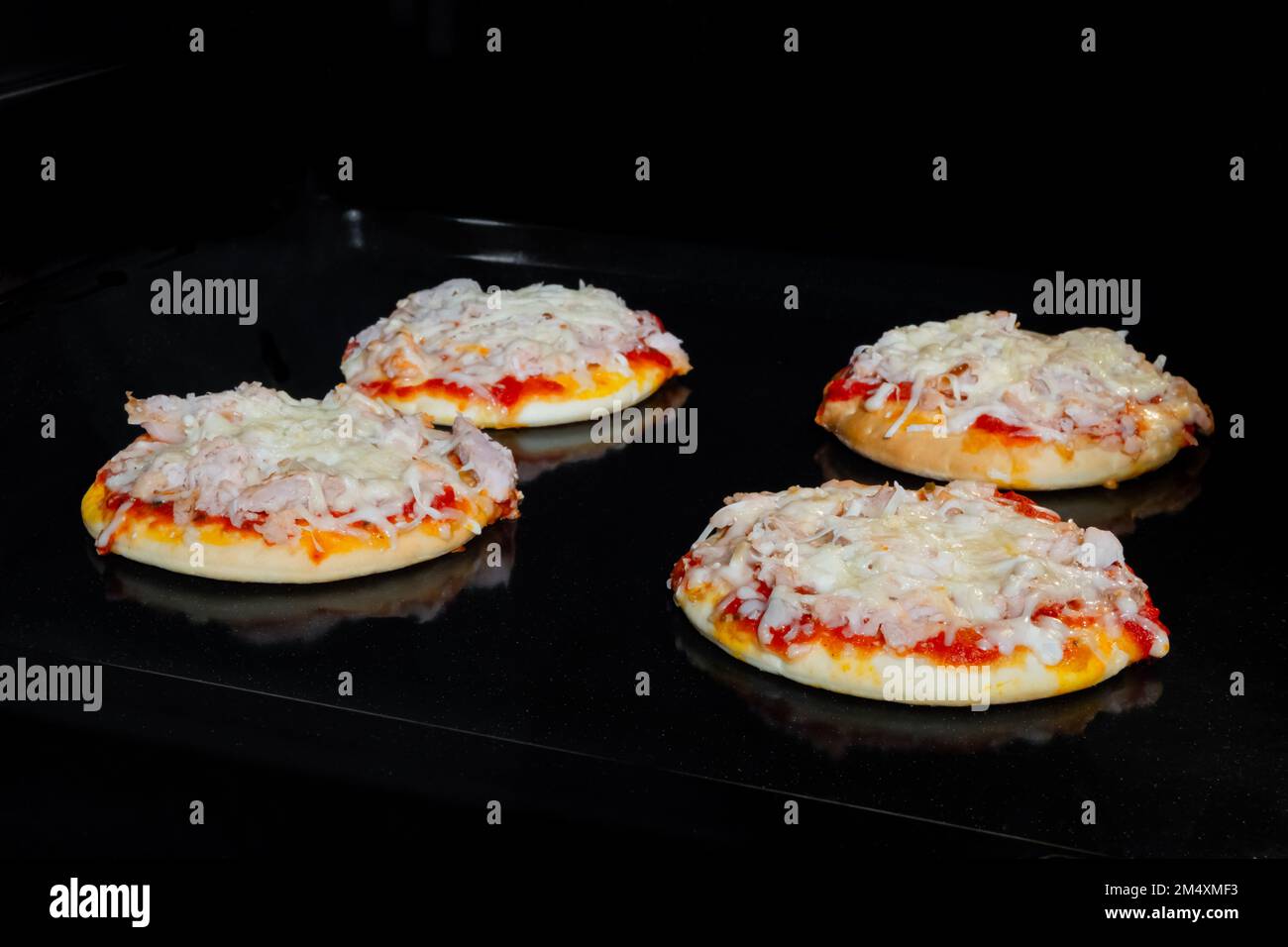 Four baked homemade mini pizzas in electric oven at home Stock Photo - Alamy