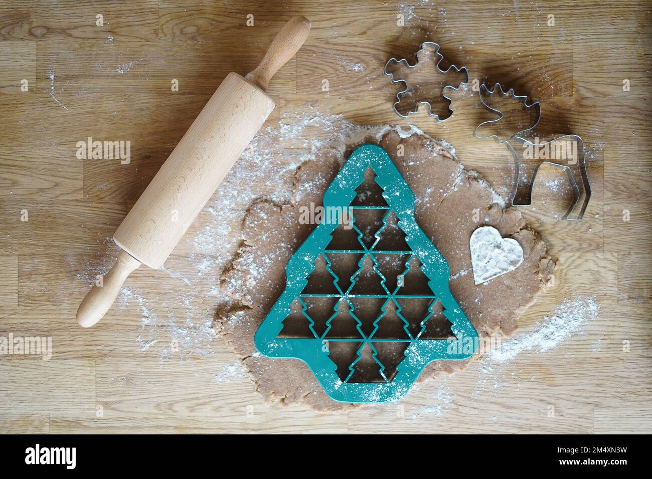 Christmas cookie mold by cutter and rolling pin with dough on table ...