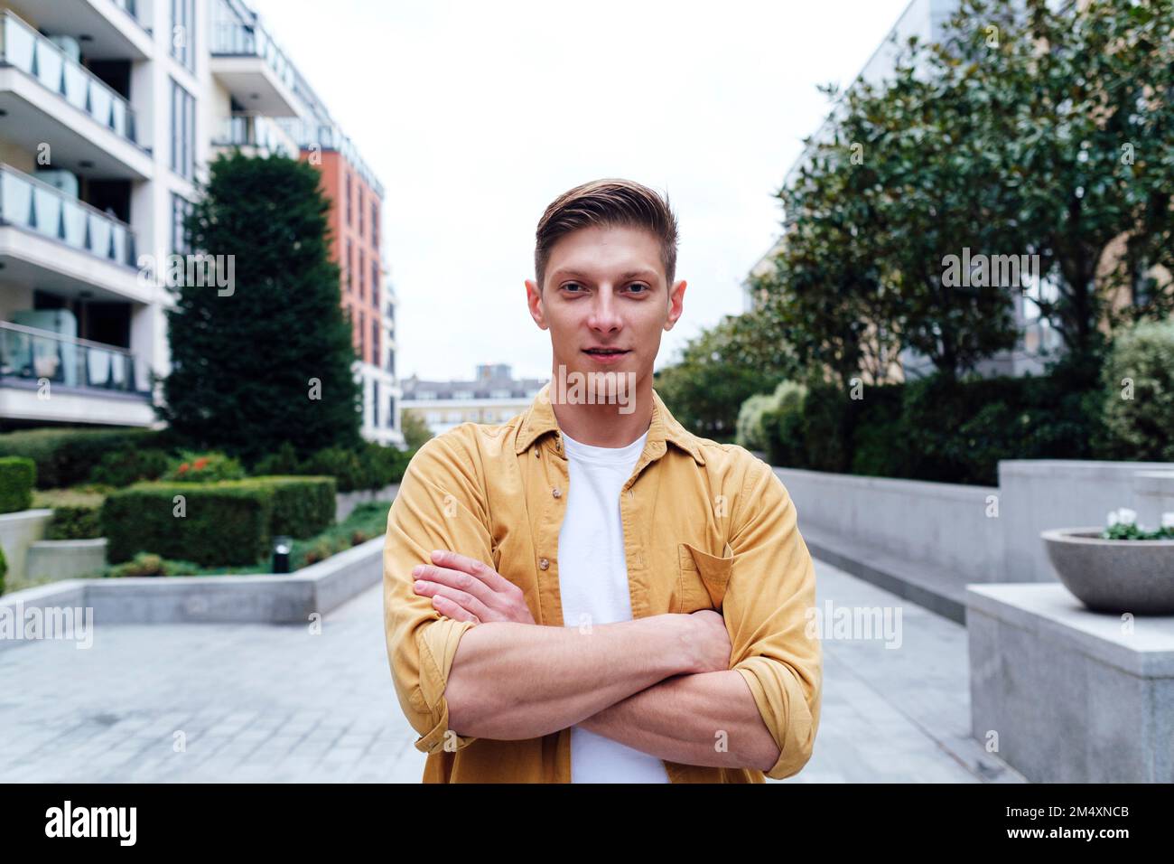 Confident handsome man standing with arms crossed Stock Photo - Alamy