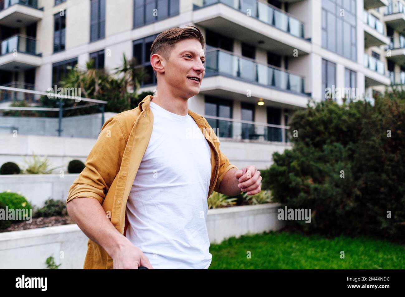 Happy young man running in front of building Stock Photo - Alamy