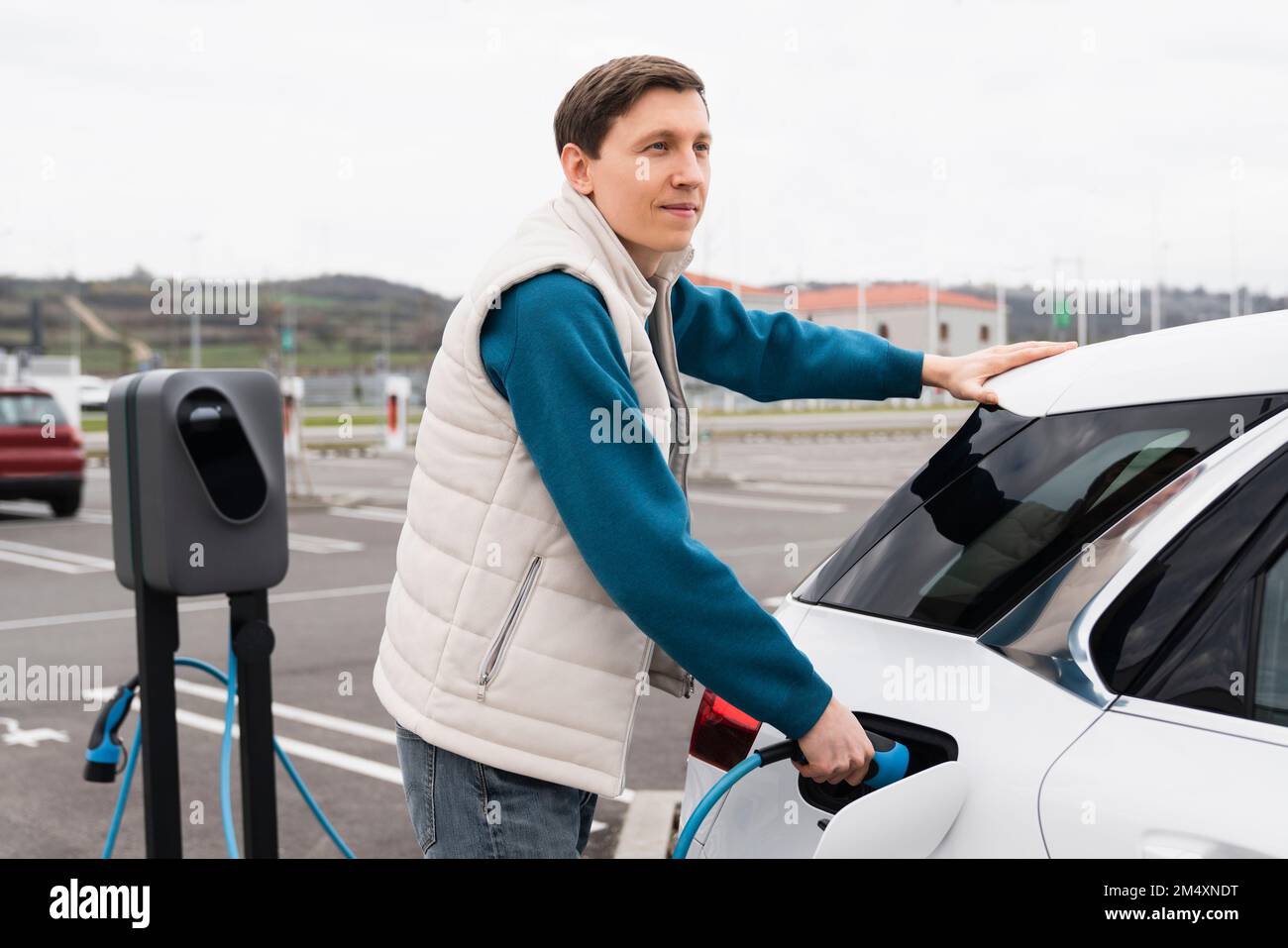 Mid adult man charging electric car hi-res stock photography and images ...