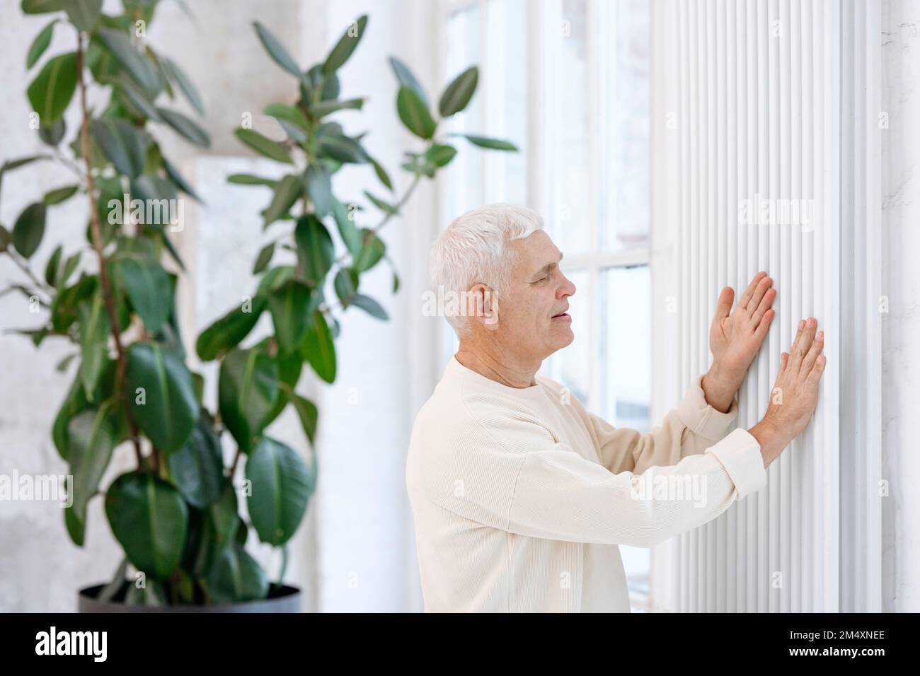 Senior man touching and examining radiator at home Stock Photo - Alamy