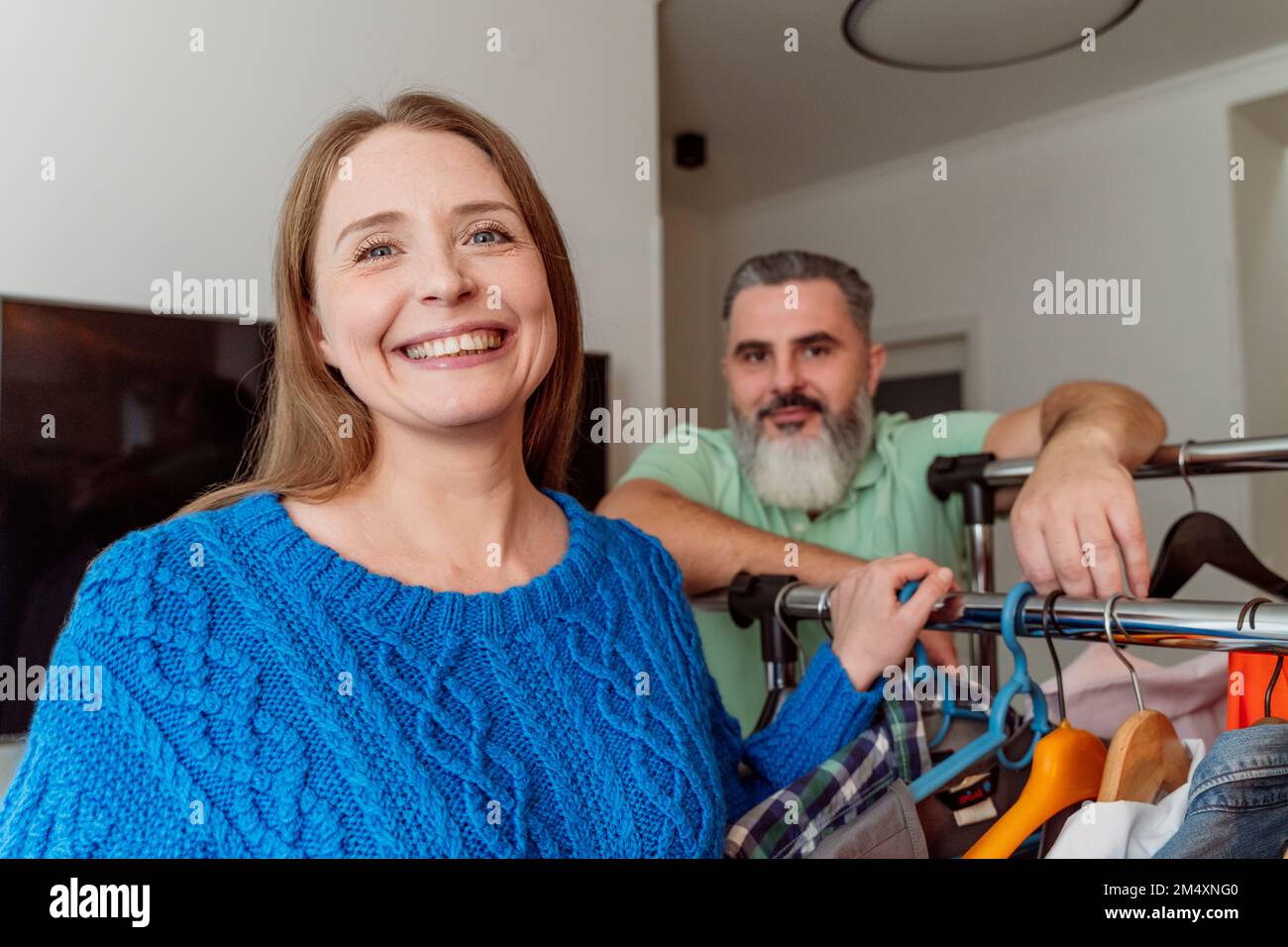 Happy couple by clothes rack Stock Photo - Alamy