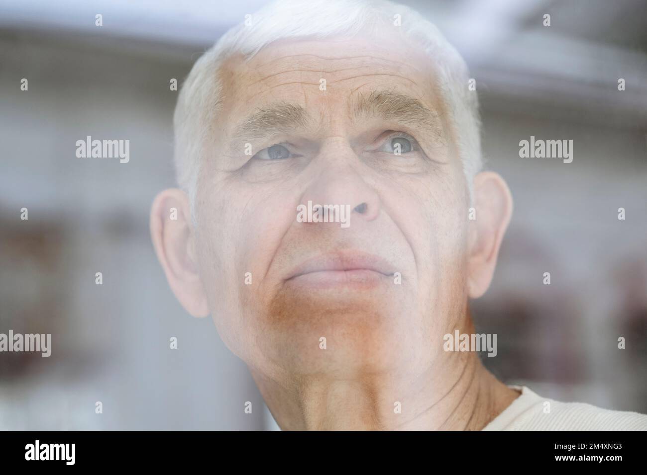 Senior man looking out of glass window Stock Photo - Alamy