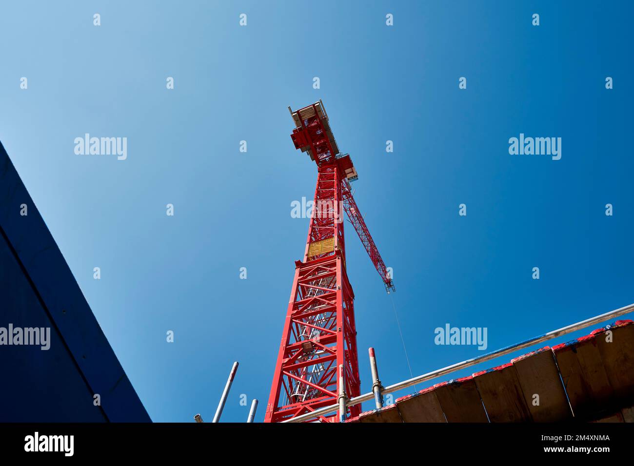 Red crane machinery under blue sky Stock Photo - Alamy