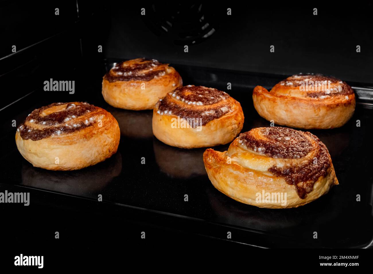 Five baked cinnamon buns in electric oven at home Stock Photo - Alamy