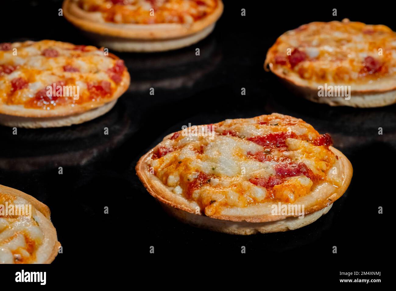 Baked homemade mini pizzas in electric oven, black background Stock Photo - Alamy