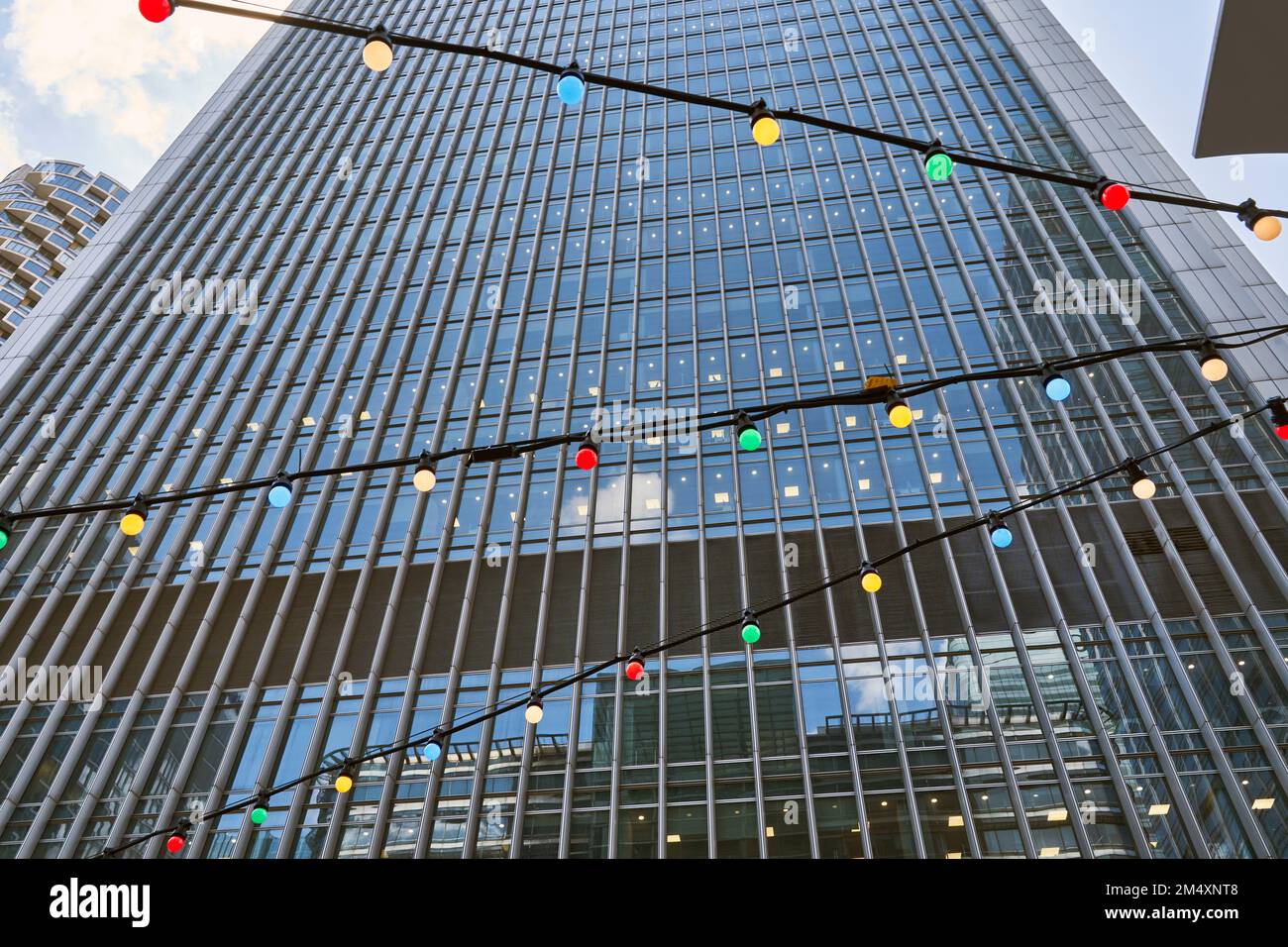 Multi colored light bulbs hanging in front of building Stock Photo - Alamy