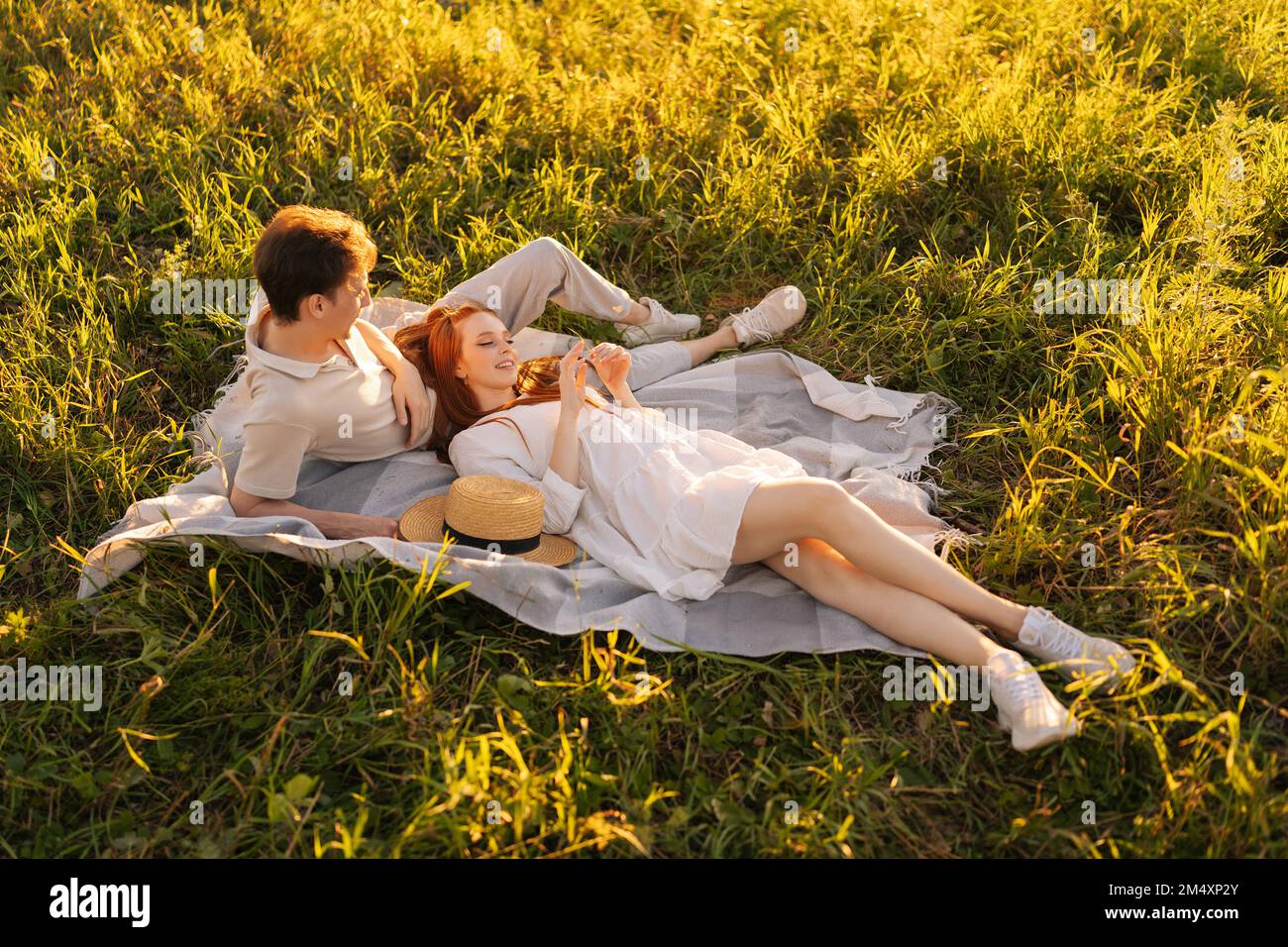High Angle View Of Happy Young Couple Relaxing In Nature Park Lying