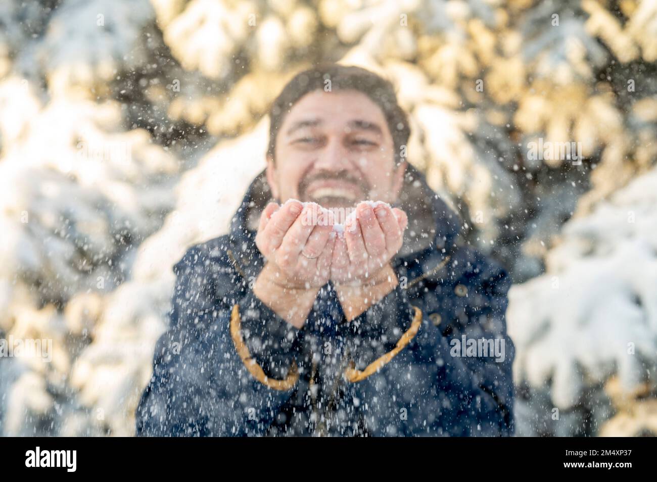 Happy man playing with snow in winter Stock Photo - Alamy