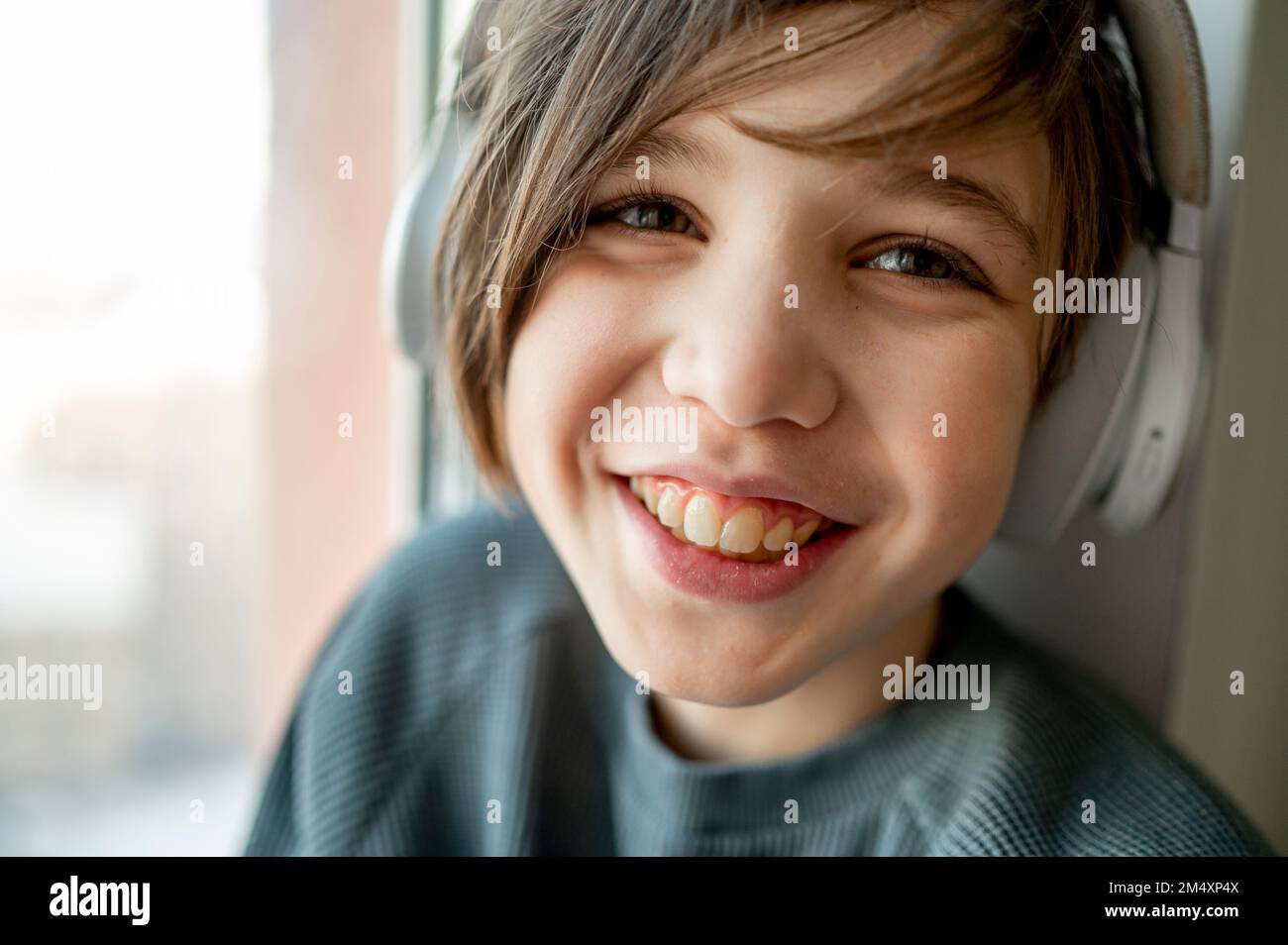 Happy boy listening to music through wireless headphones Stock Photo ...