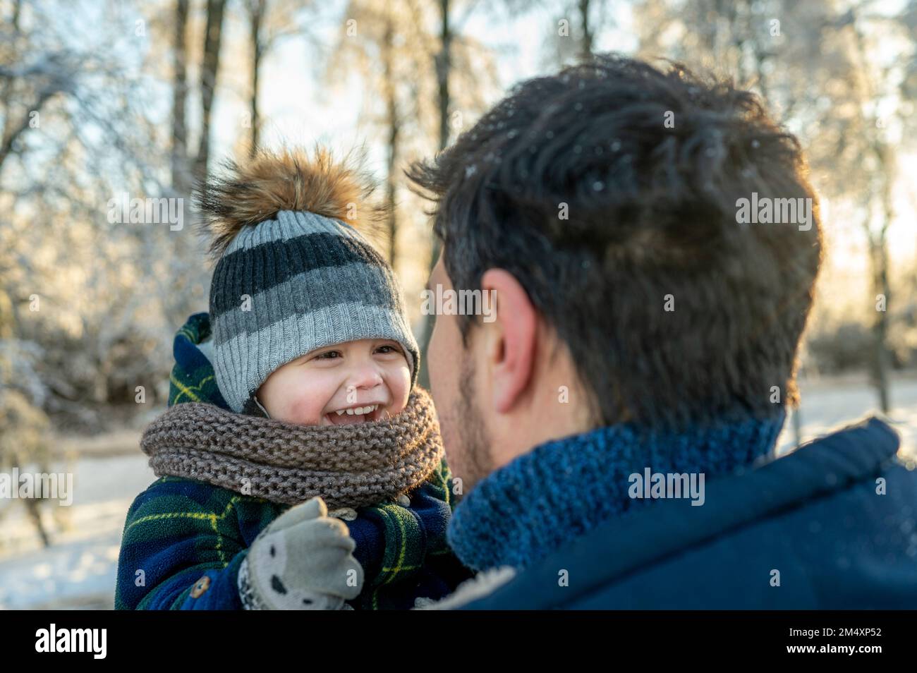 Happy cute boy with father wearing warm clothing in winter park Stock ...